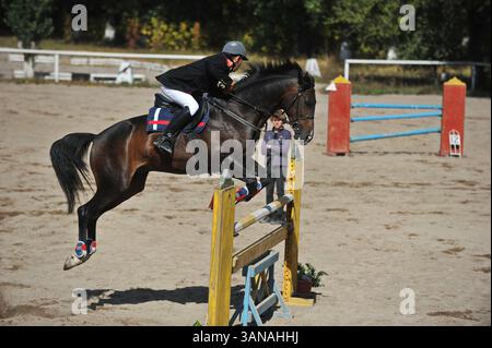 Jumping competition. Athletes and their horses train on a platform with ...