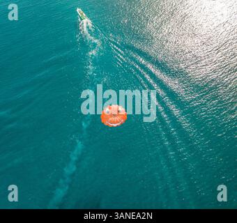 Aerial view of parachute with smiley face being pulled by boat ...