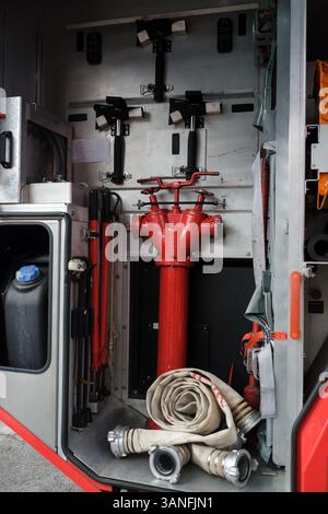 Fire truck equipment showcasing a red fire hydrant connection and hoses ...