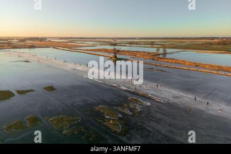 Aerial view of Ypey-Mole windmill with with ice skaters surrounded ...