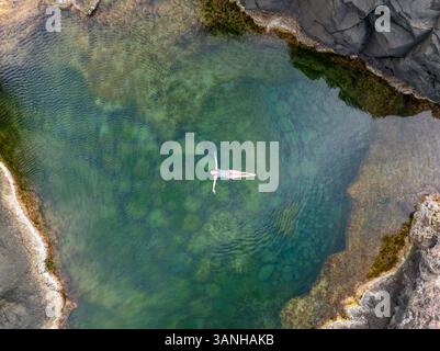 Aerial view of a woman swimming at Mosteiros Rock Pool, Piscinas ...