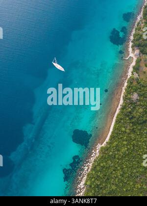 Aerial view of single speed boat floating over transparent water ...