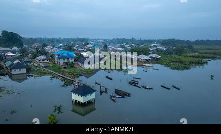 Aerial view of a tranquil waterside village with lush greenery and ...