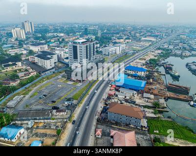 Aerial view of NDDC building and bustling waterfront with boats and ...