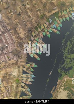 Aerial view of bustling boats and cement industries along the Buriganga ...