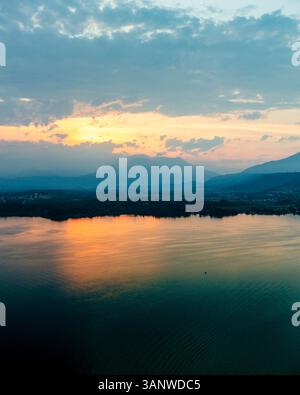 Aerial view of serene Viverone Lake surrounded by lush greenery and a ...