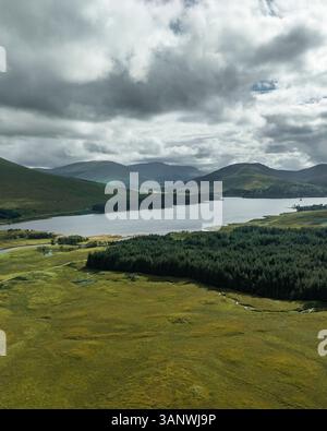 Aerial view of serene Loch Tulla surrounded by majestic mountains and ...