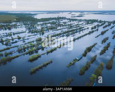 Aerial view of flooded Scheendijk with floating houses and boats ...