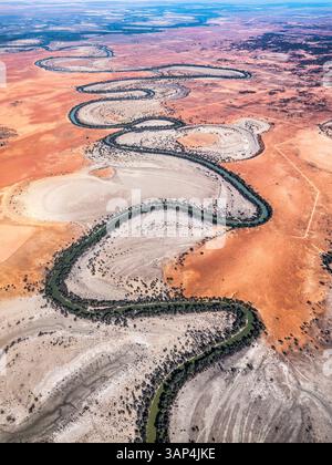 Vast desert landscape with a winding river and distant mountains under ...