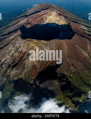 Aerial view of the majestic Agung volcano peak piercing through a sea ...