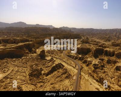 Aerial view of rugged desert terrain with winding road, Balochistan ...