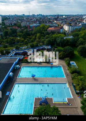Aerial view of vibrant public pools surrounded by high rise buildings ...