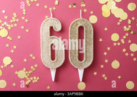 60th birthday. Number shaped candles and confetti on violet background ...