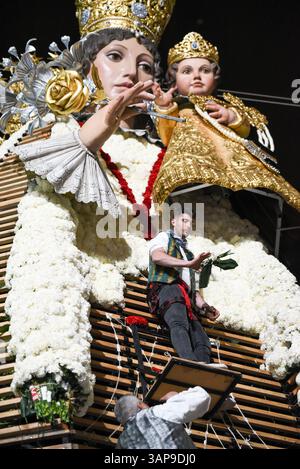 Men in traditional costume climbed on a giant wooden structure ...
