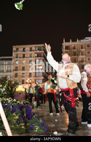 Men in traditional costume climbed on a giant wooden structure ...