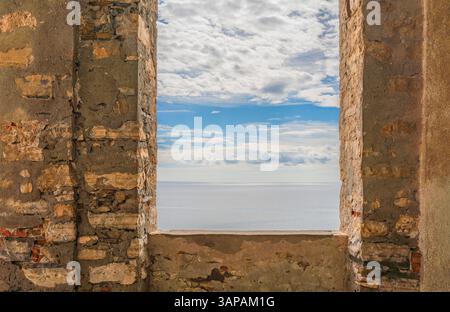 Sunny mediterranean sea scenery seen through a window opening in a ...