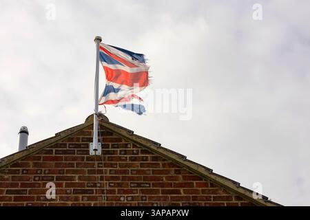 Ripped Union Jack Flag blowing in the wind Stock Photo - Alamy