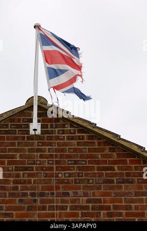 Ripped Union Jack Flag blowing in the wind Stock Photo - Alamy