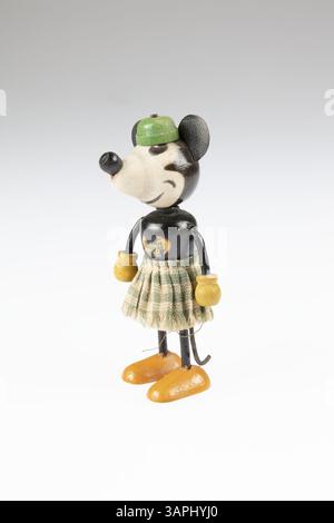 An early wooden Minnie Mouse doll, featuring a green and white skirt ...