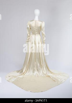 The ivory rayon satin wedding dress and tulle veil made and worn by ...