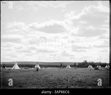 This historical photograph depicts Native Americans spearing salmon, a ...