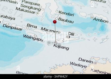 Close up to a Kupang city with a red pin needle into Indonesia country ...