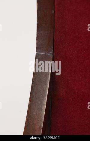 A high-backed priest's chair with red velvet upholstery, featuring a ...