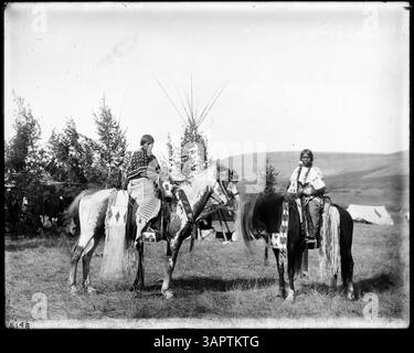 Nez Perce women in traditional regalia are shown riding horses ...