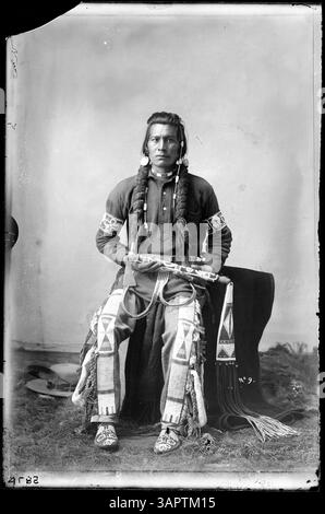 This photograph depicts a Yakima Indian dressed in various regalia ...