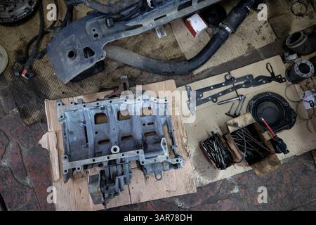 An overhead view shows various disassembled engine components laid out ...
