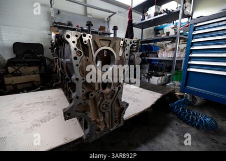 A disassembled diesel truck engine block stands in a repair shop or ...
