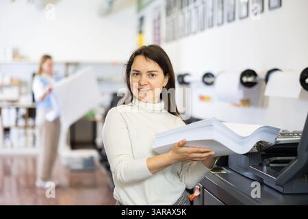 Technician worker operator changes the paper roll on large premium ...