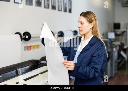 Print worker controlling printing process on modern offset machine in ...