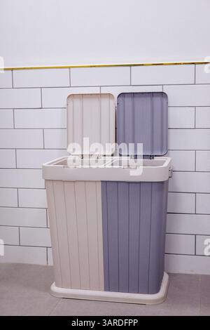 A contemporary kitchen features a dual compartment waste bin designed ...