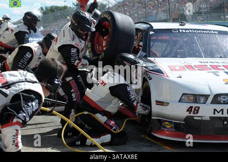 The crew of Joey Logano changes tires during a pit stop during a NASCAR ...