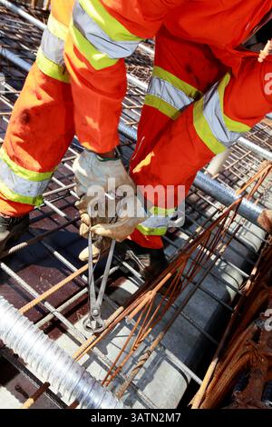detail of worker tying steel rebar on road construction on countryside ...