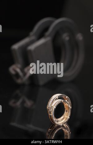 Engagement rings and handcuffs on a glass studio background Stock Photo ...