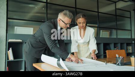 Business team reviewing architectural plans with 940,158 followers ...