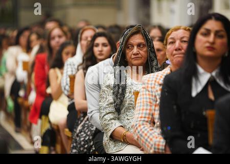 Al Hamdaniya, Iraq. 19th Apr, 2025. A Syriac Catholic priest carries ...