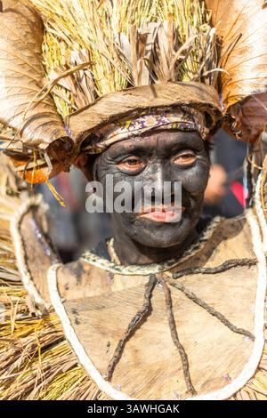 Participant in black face paint to honor the Ati tribe and wearing ...
