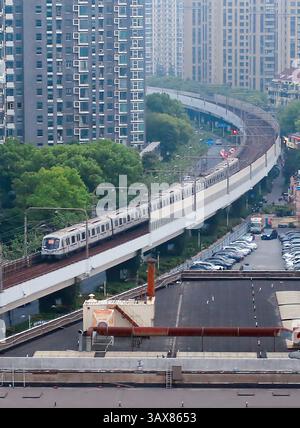 Shanghai Metro Line 3 runs among high-rise buildings in Shanghai, China ...