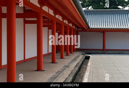 A covered walkway with a vermilion colonnade and kawara tile roof is an ...
