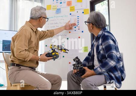 asian Engineers discussing robotics prototype with teamwork and ...