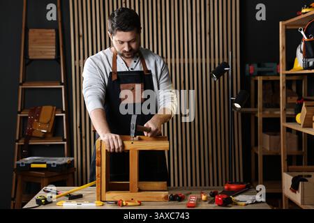 Carpenter repairing stool at table in workshop Stock Photo - Alamy