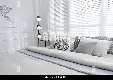 Lamp near bed in stylish room. Interior design Stock Photo - Alamy