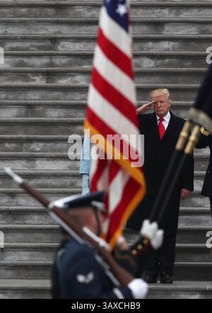 US President Donald Trump salutes military service members as he ...