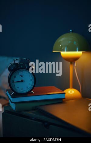 Illuminated yellow alarm clock on yellow background with colorful ...