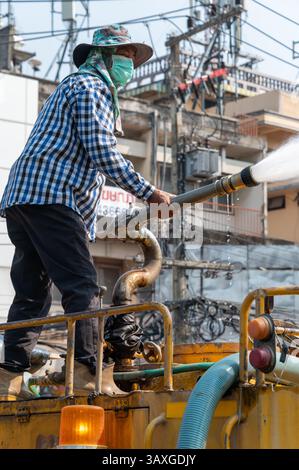 A local parks employee using a water pressure jet hose from a mobile ...