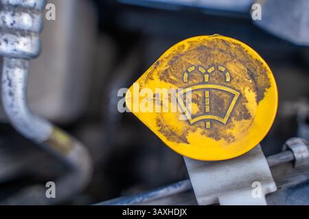 Car windshield washer filler cap, yellow Stock Photo - Alamy