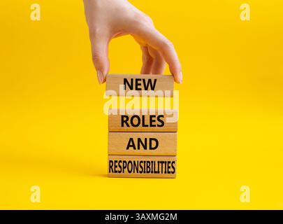 New roles and responsibilities symbol. Wooden blocks with words 'New ...